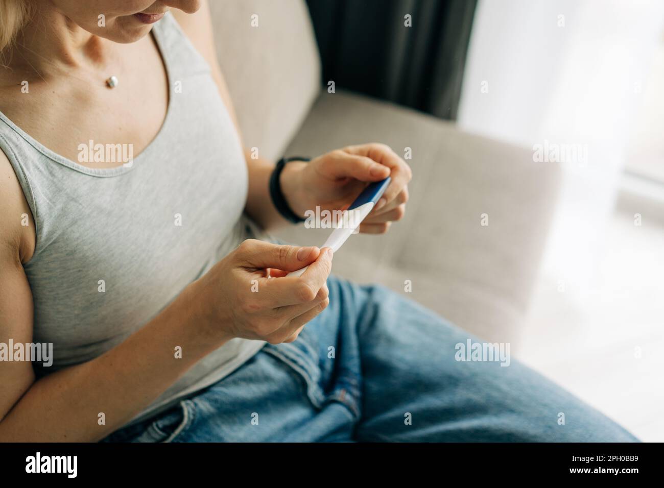Unrecognizable woman checking pregnancy test, waiting for test result ...