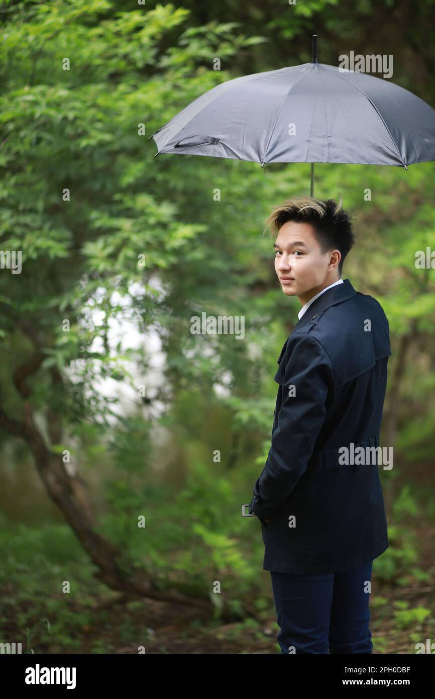 Spring Park in rainy weather and a young man with an umbrella Stock ...
