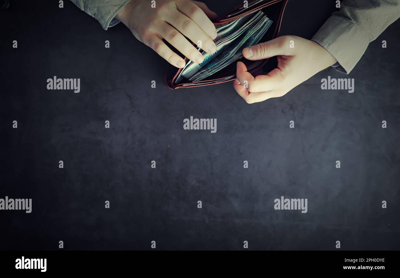 Hands take out cash banknotes from a wallet on gray background. Foreign ...