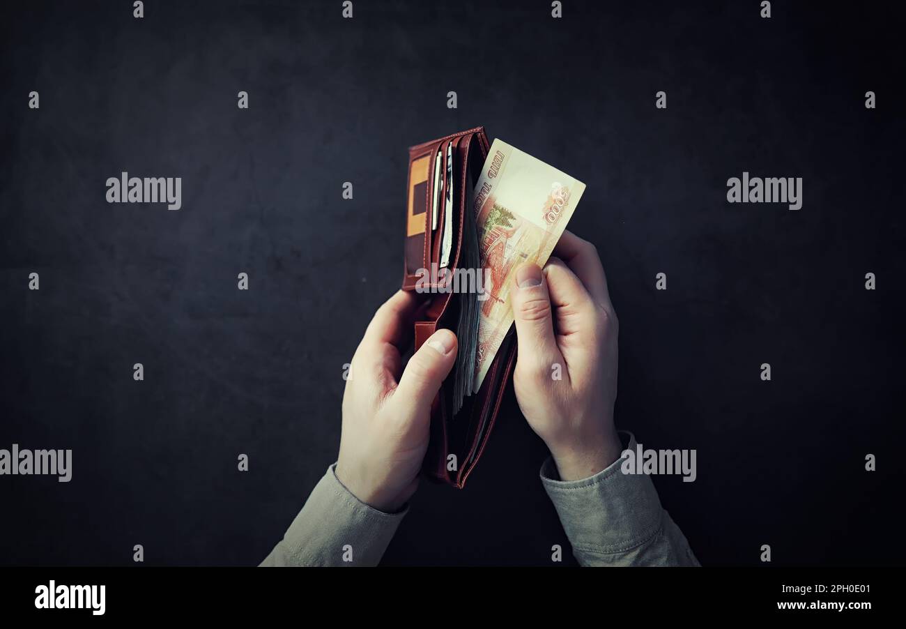 Hands take out cash banknotes from a wallet on gray background. Foreign ...