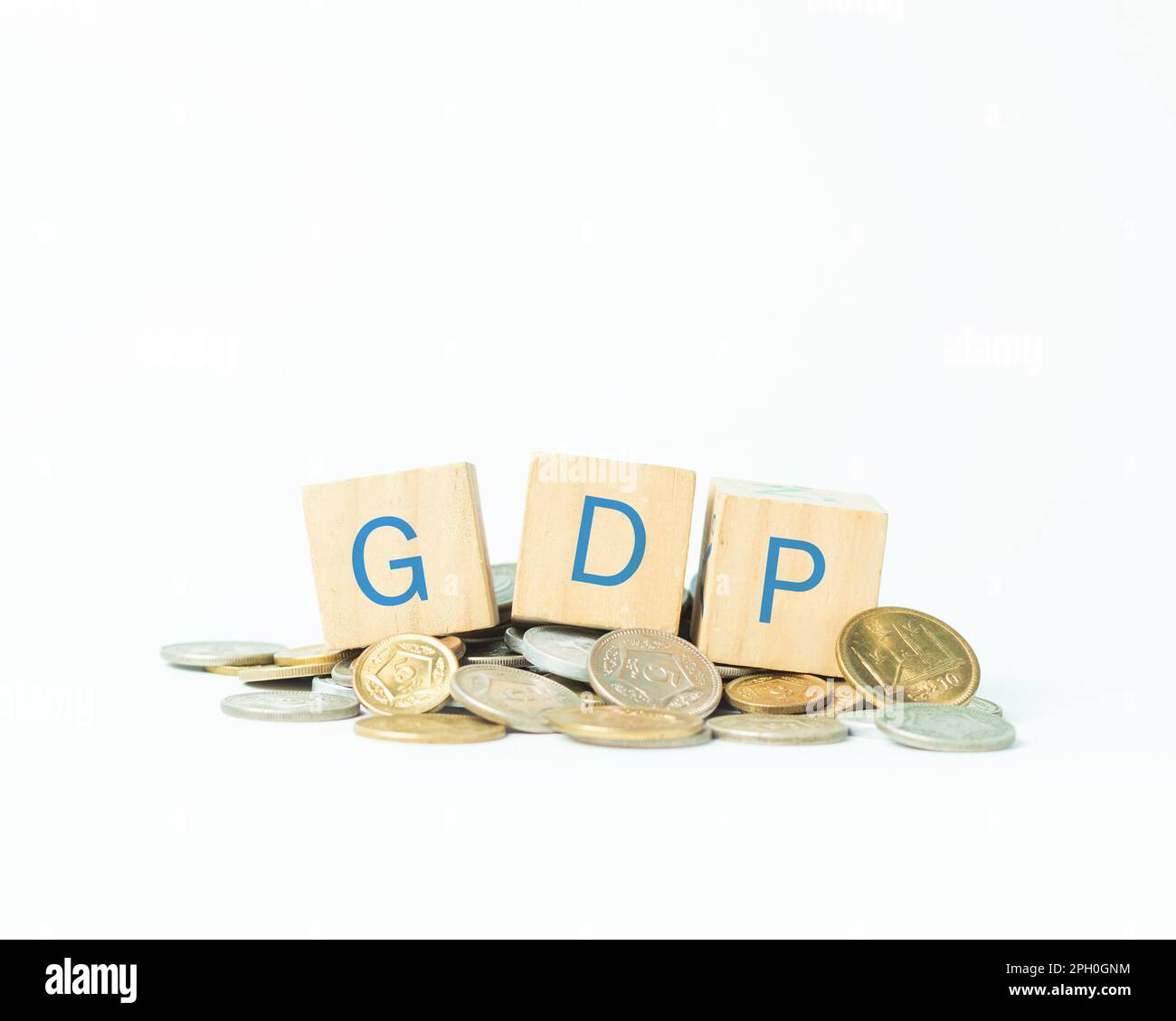 Word GDP written on toy blocks and coins on table with white background ...