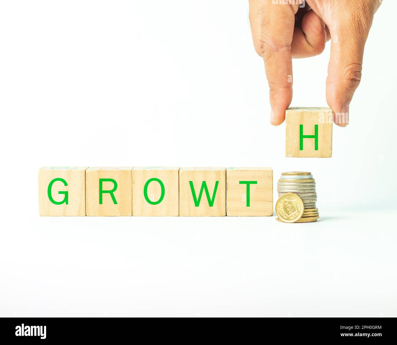 Word GROWTH written on toy blocks and coins on table with white ...