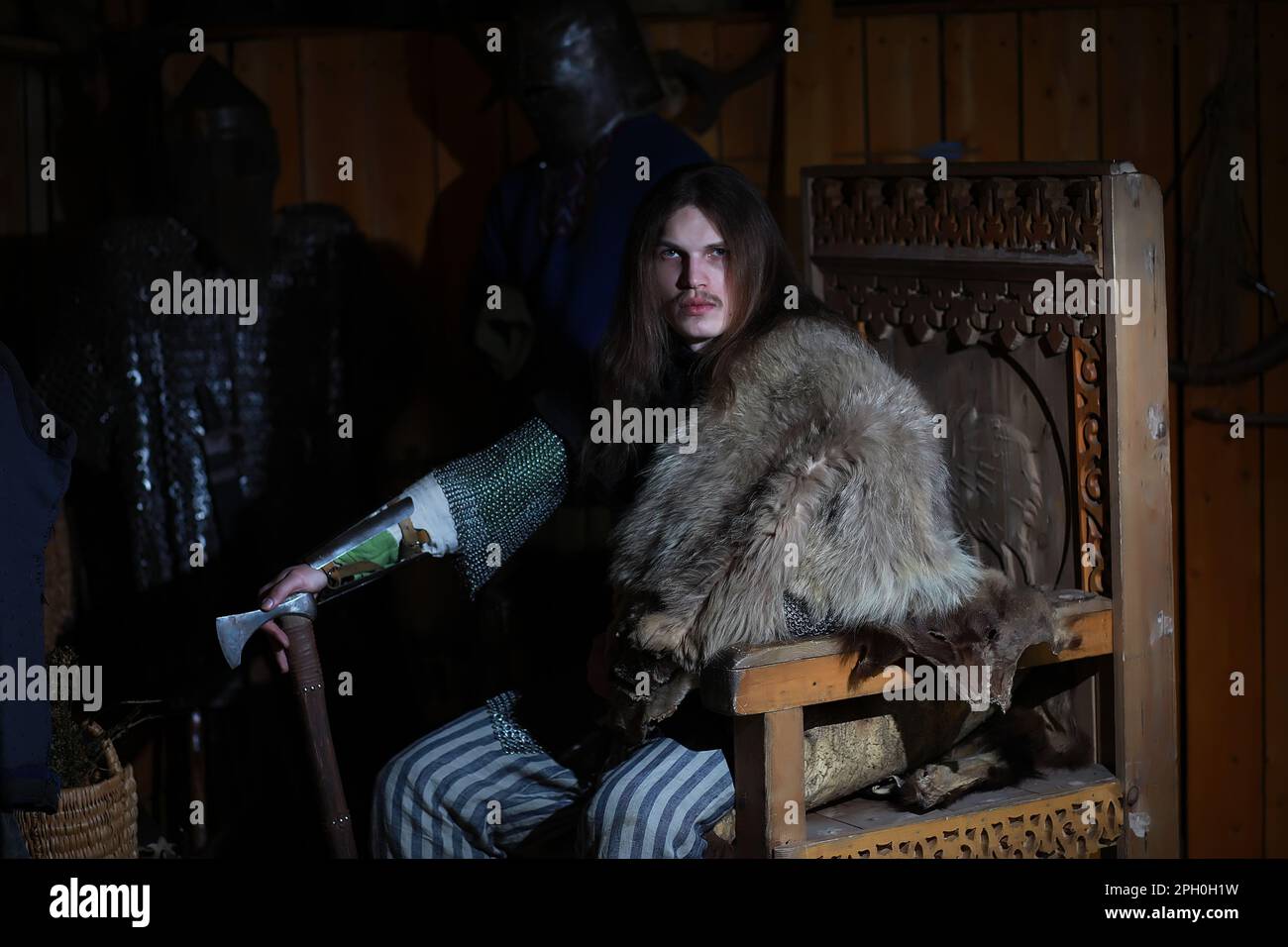 A mighty hero with long hair in chain mail armor in an ancient hall ...