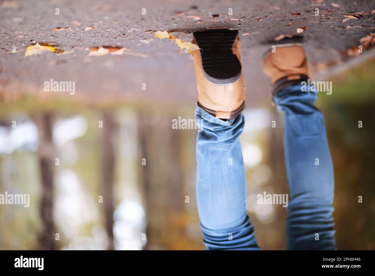 Autumn concept. Pedestrian feet on the road. Autumn leaves on footpath ...