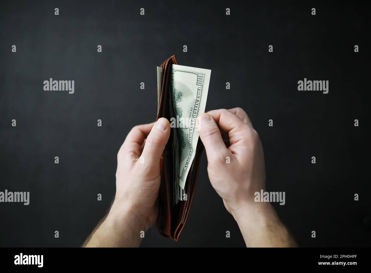 Hands take out cash banknotes from a wallet on gray background. Foreign ...