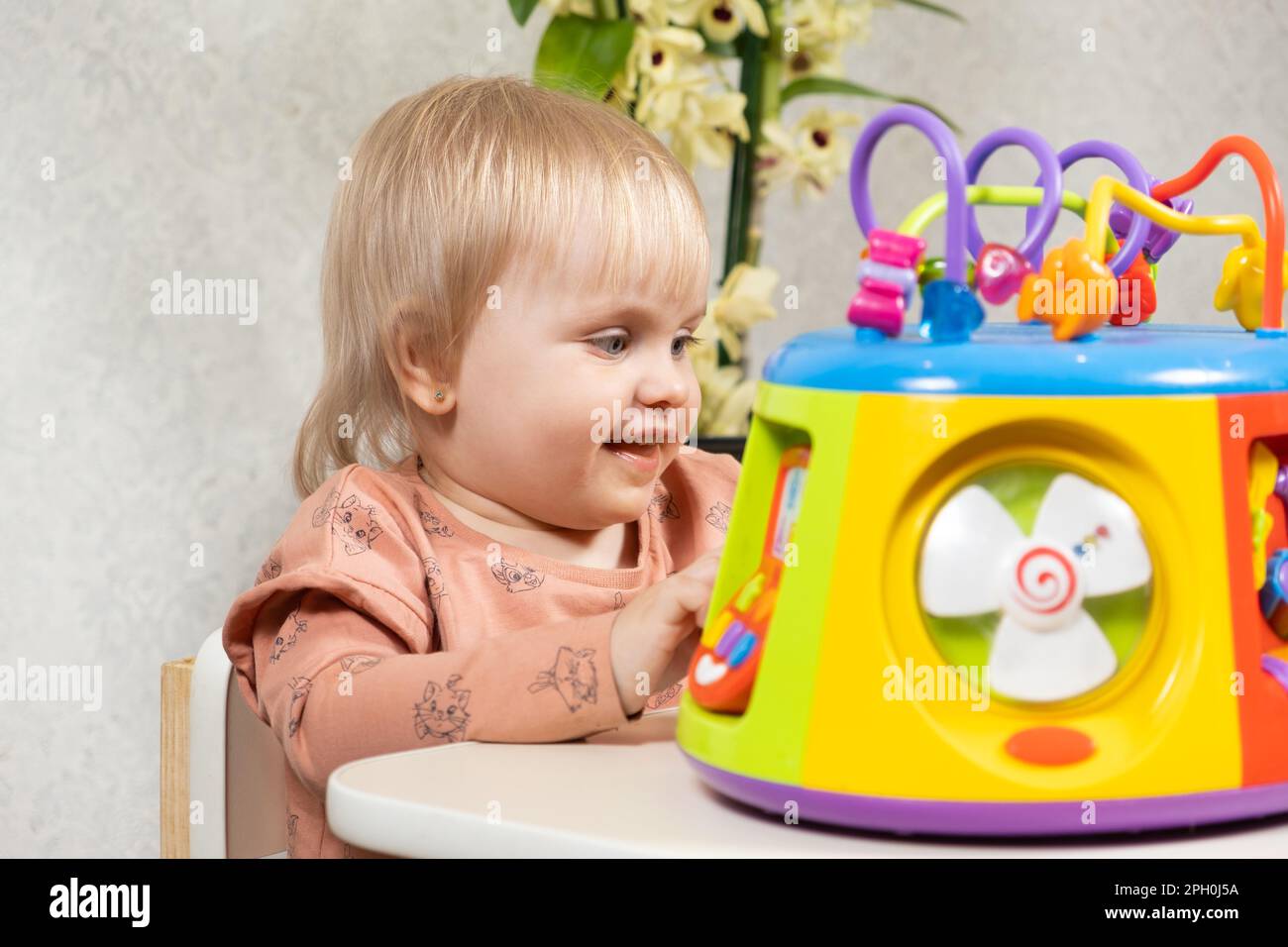 A one-and-a-half-year-old girl plays with a musical glowing toy ...