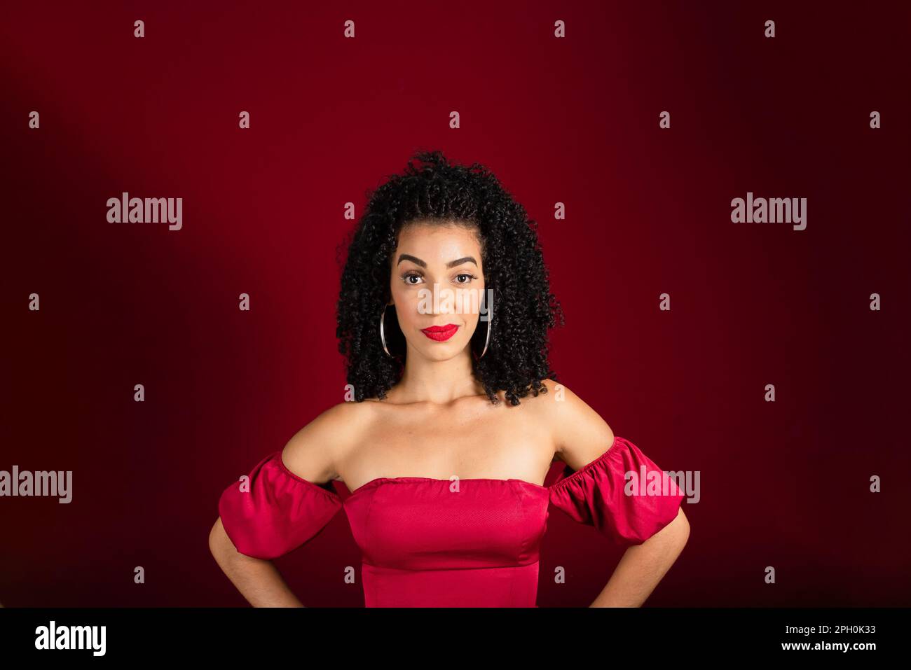 Beautiful and calm woman, standing, posing for the photo. Isolated red ...