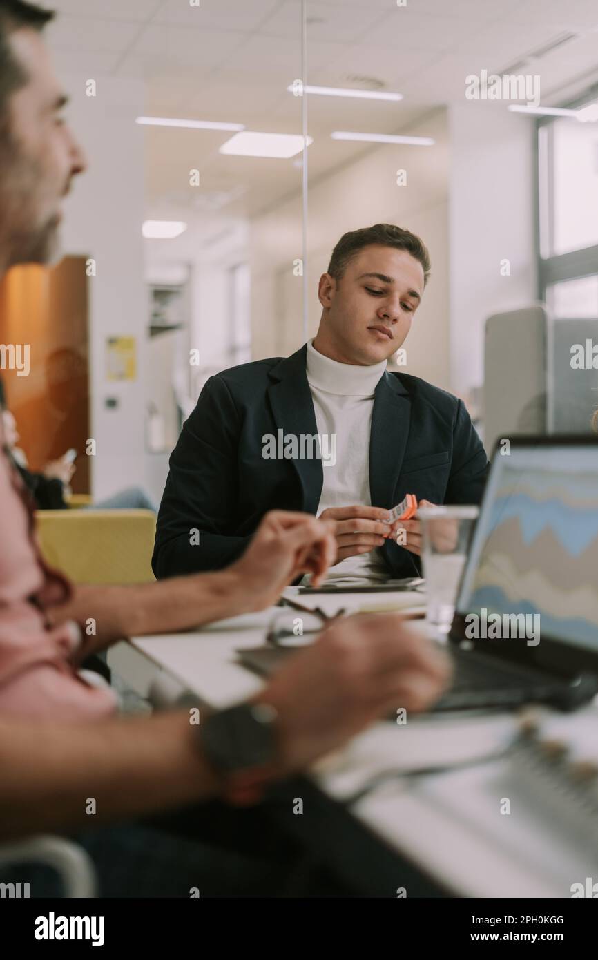 Young bored male person playing with the sticky notes at the middle of ...