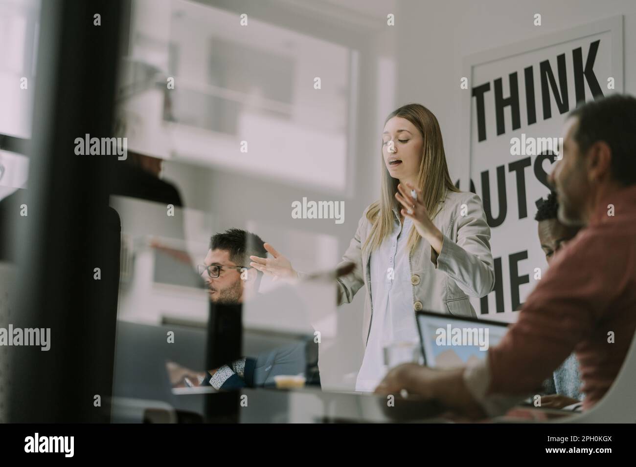 Beautiful blonde business girl explaining something to her colleagues ...