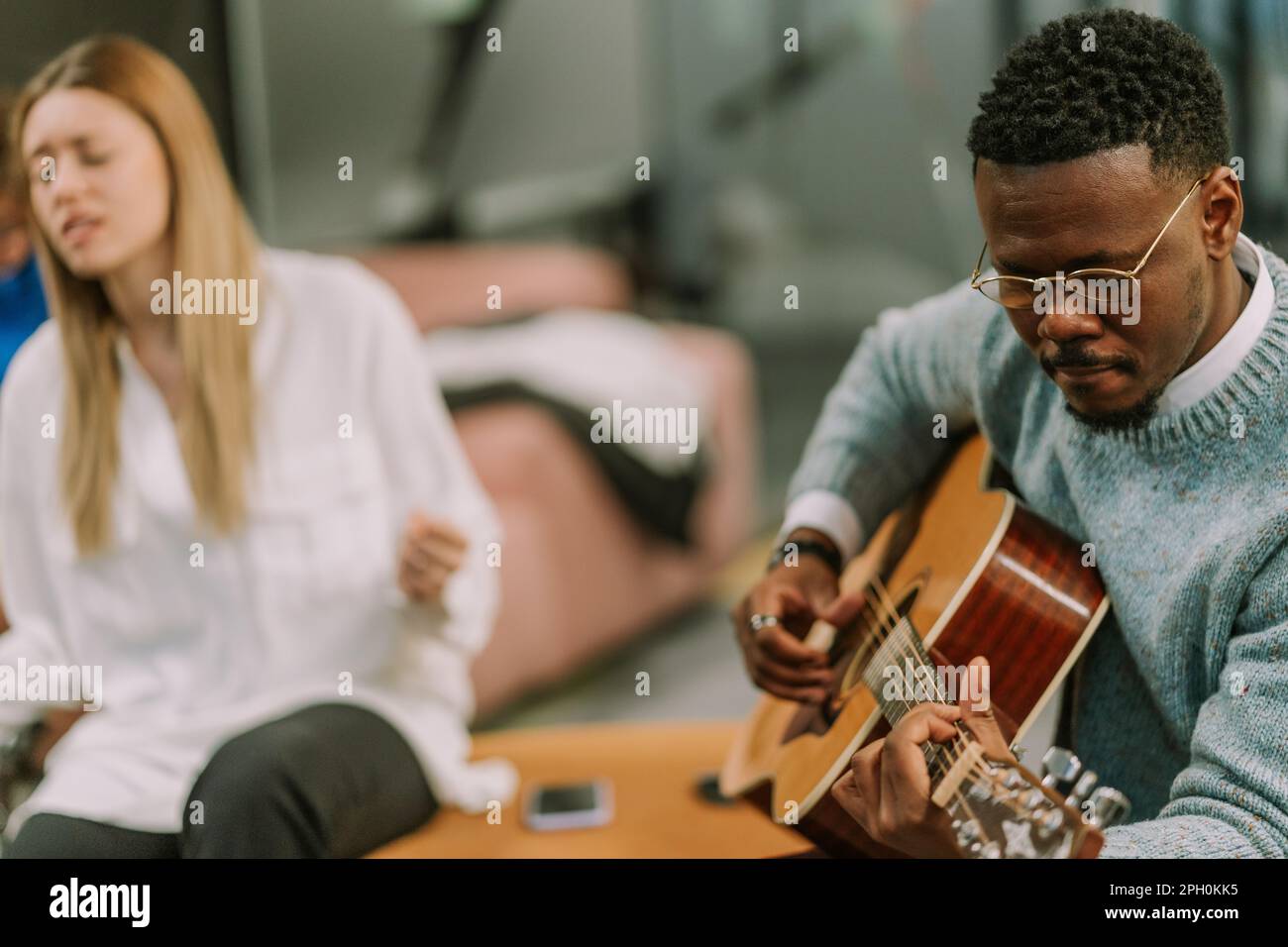 A photo of good looking black male person playing guitar. His female ...