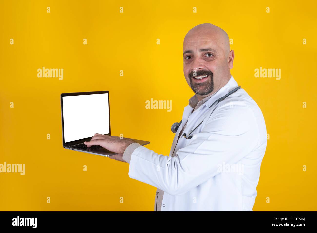 cheerful middle aged European male doctor holding, typing laptop with ...