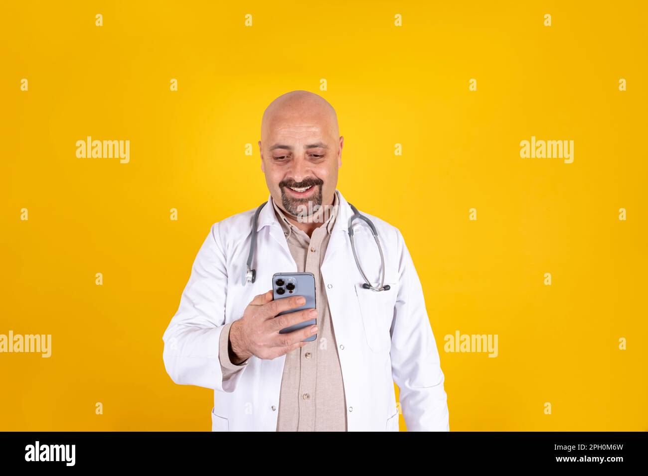 General practitioner doctor holding telephone in his hand. Middle aged ...