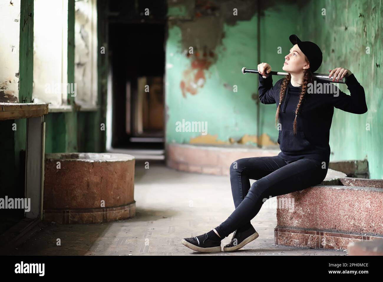 A young person with a baseball bat in an abandoned building Stock Photo ...