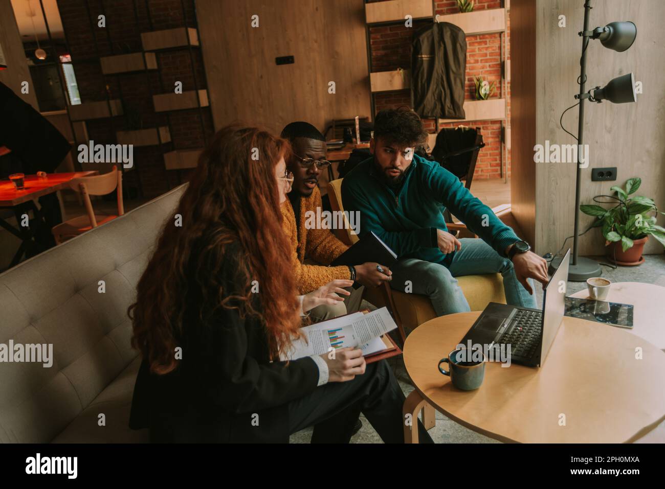 Three young programmers looking for a solution at their code while ...