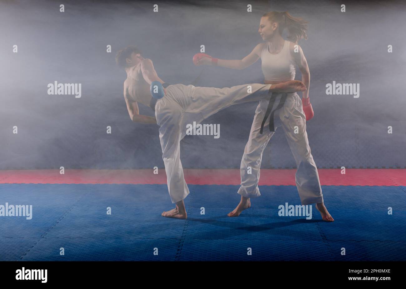 Close up of two young karate friends doing the Mawashi Geri pose at the ...