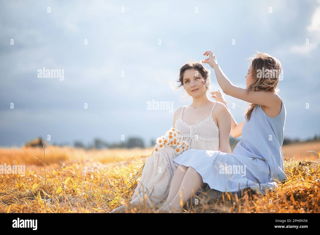 Two beautiful girls in dresses in autumn field have fun Stock Photo - Alamy