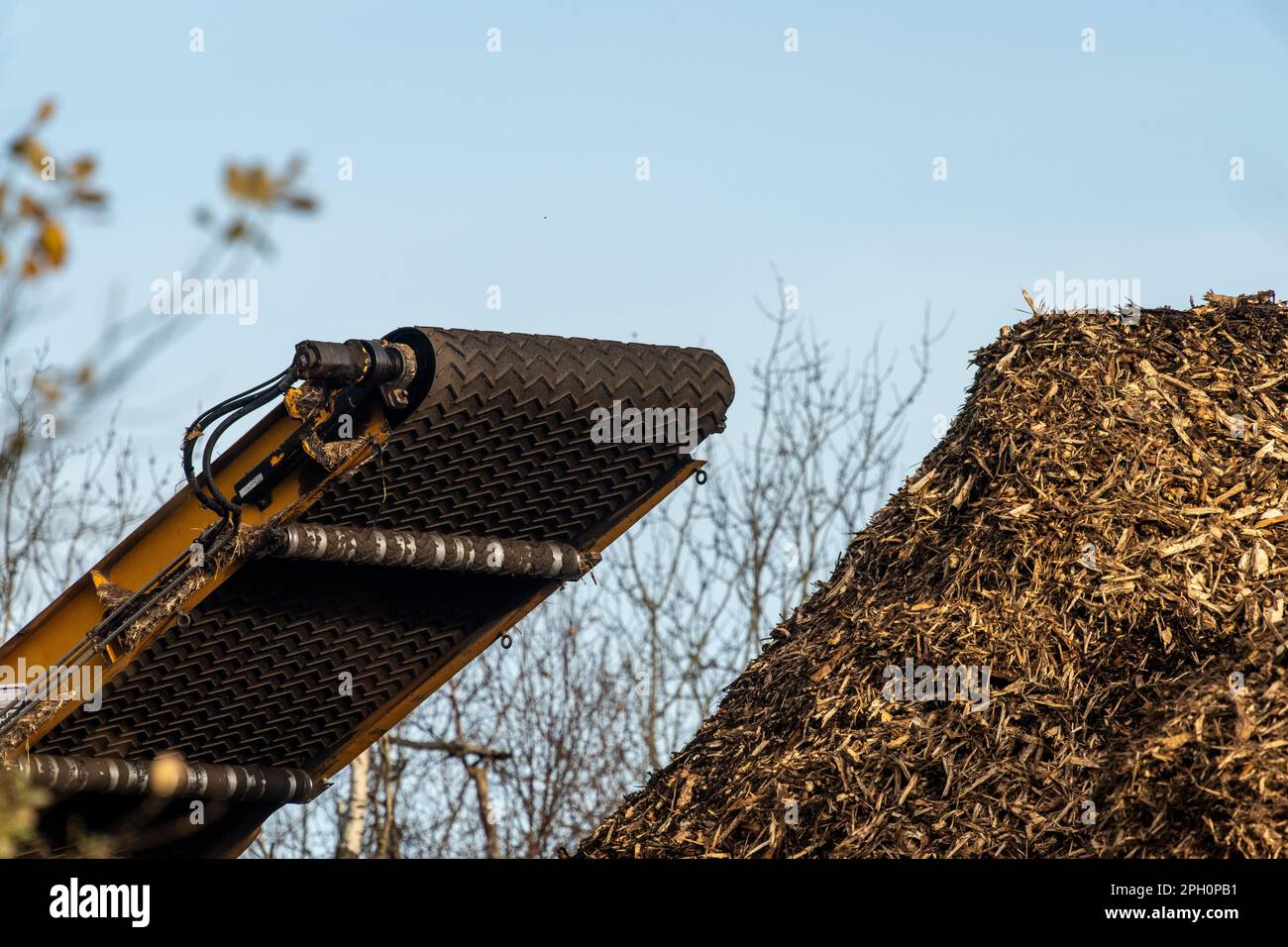 Gothenburg, Sweden - november 10 2022: Wood chips dumped in a pile by a large industrial wood ...