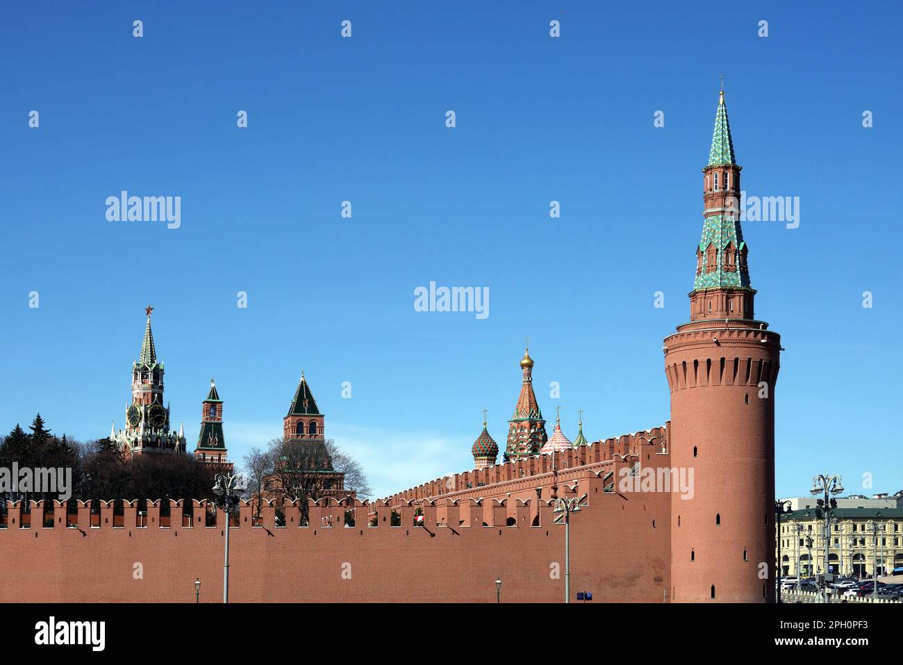Long red brick Kremlin wall with towers with spires and stars under ...