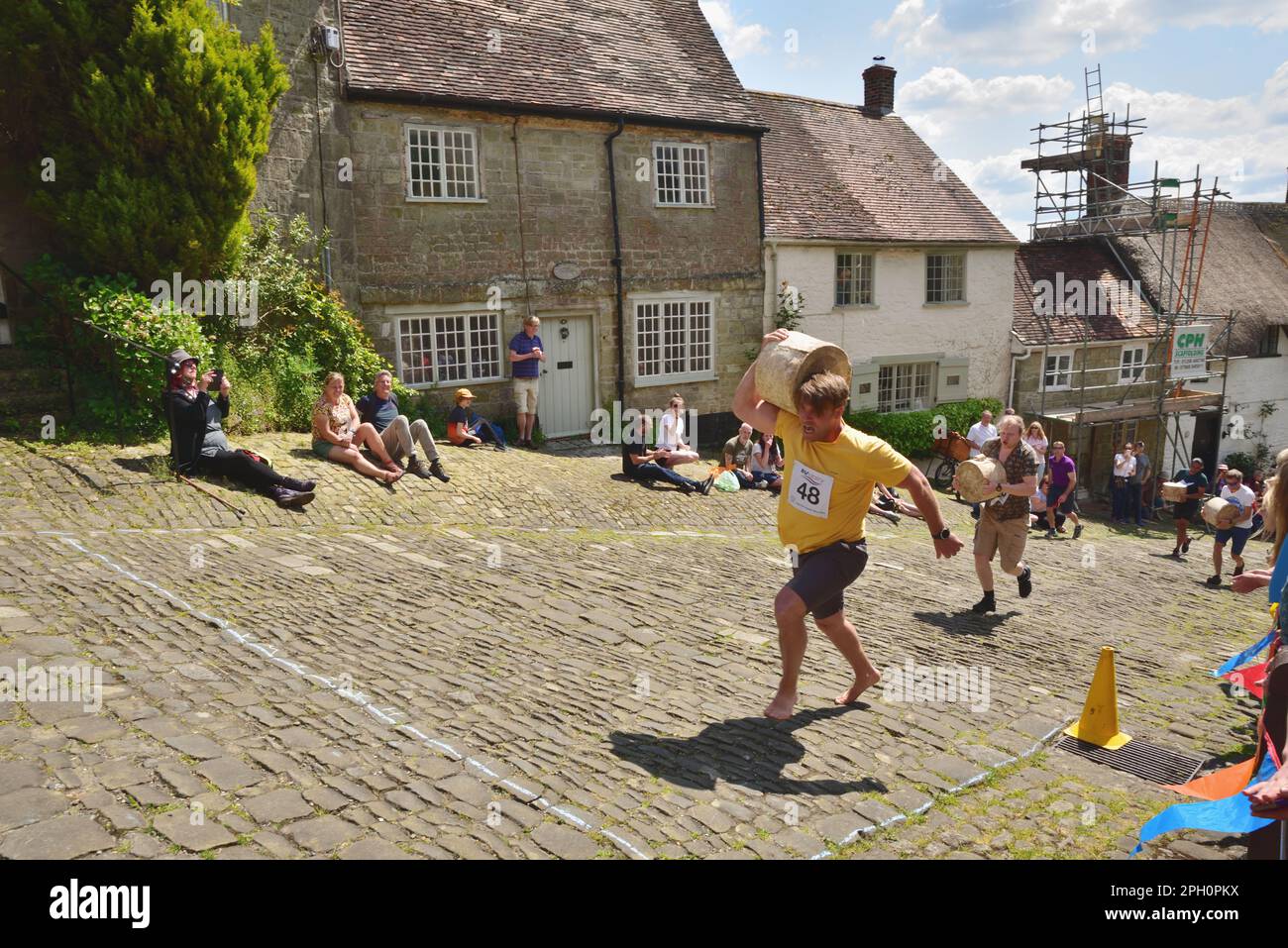 Competitors in the Men's cheese race carry their cheeses up Gold Hill ...