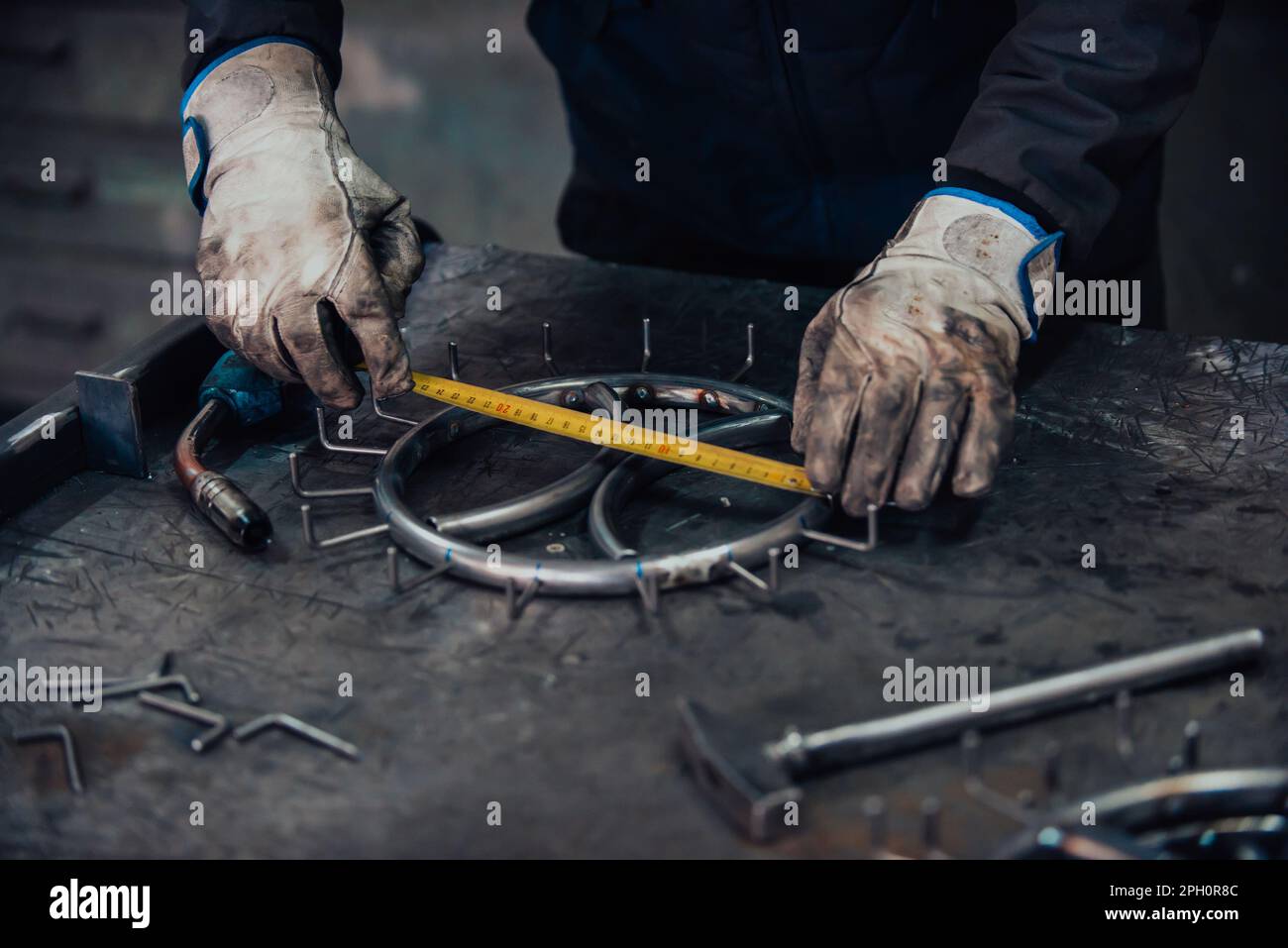 The locksmith measures the pieces of steel and preparing them for ...