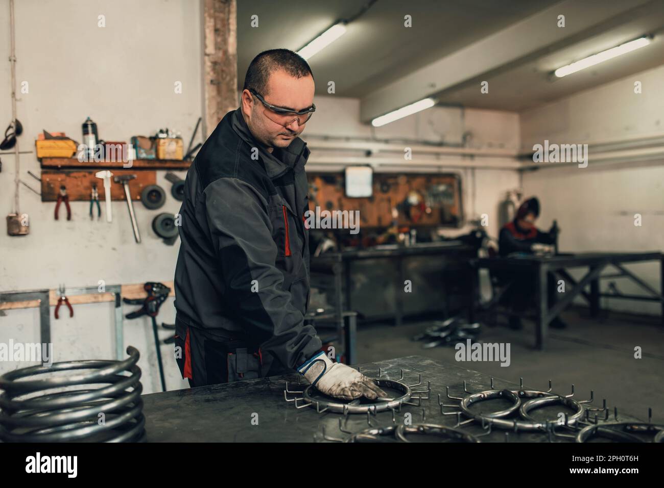 The locksmith measures the pieces of steel and preparing them for ...