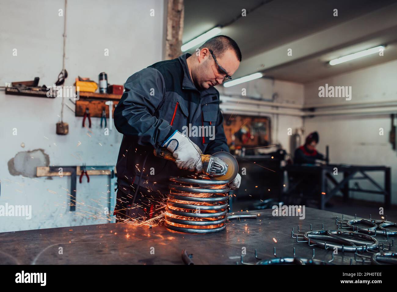 Locksmith in special clothes and goggles works in production. Metal ...
