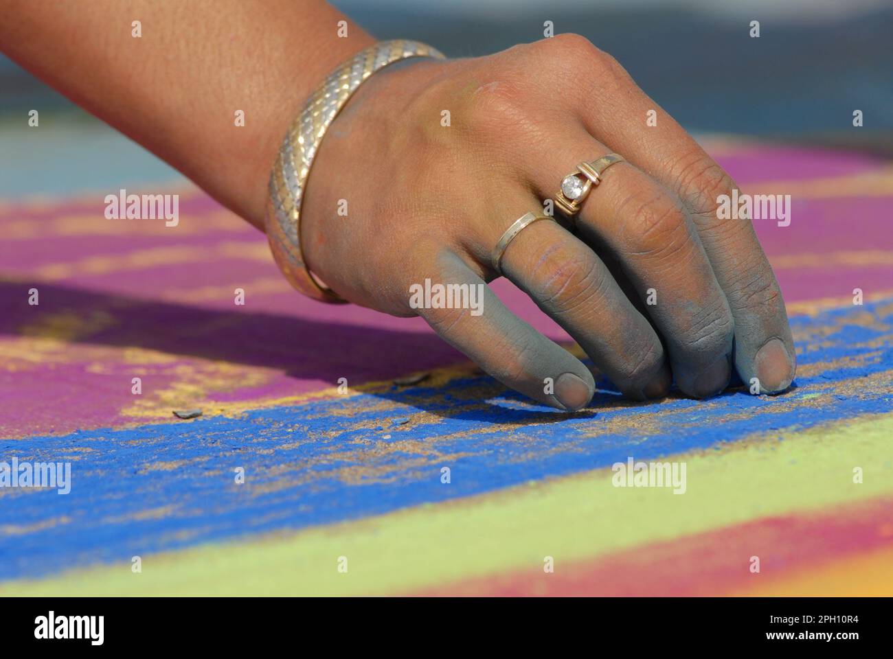 An artist hand at work making beautiful works of art on the street ...