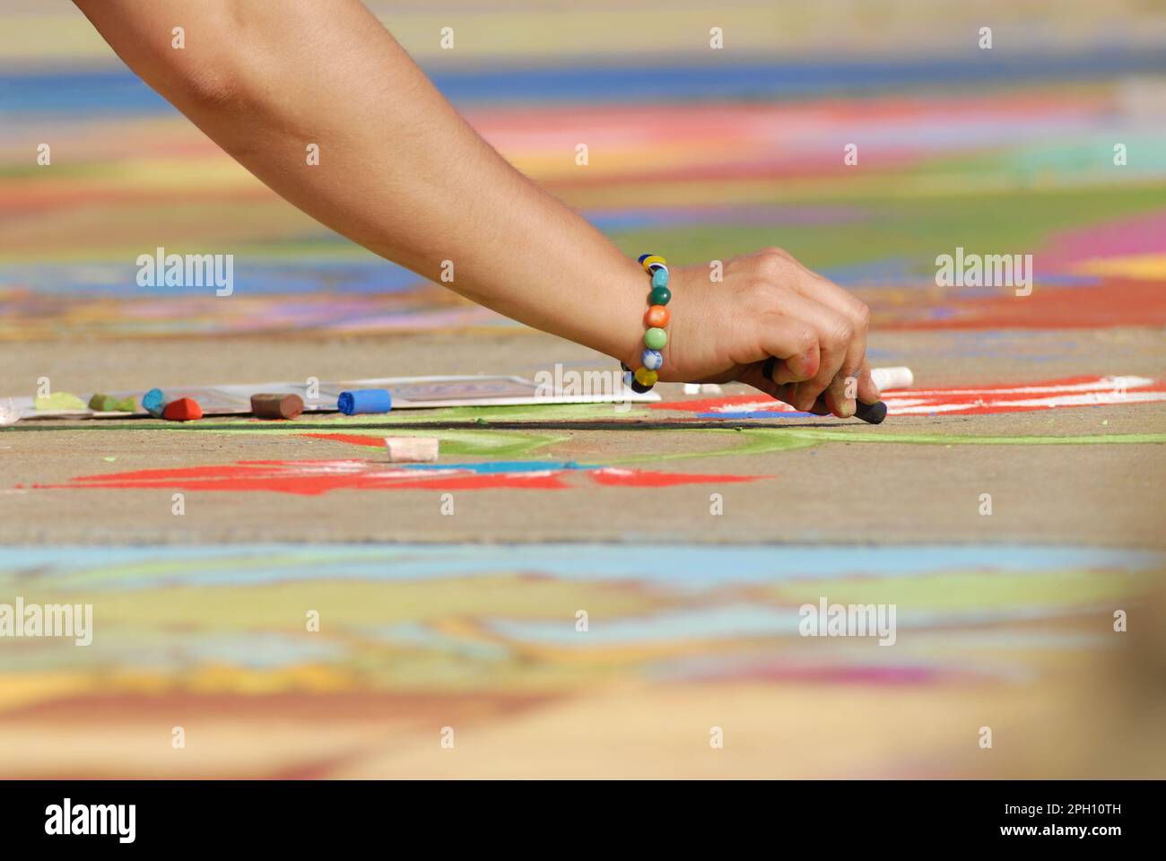 An artist hand at work making beautiful works of art on the street ...