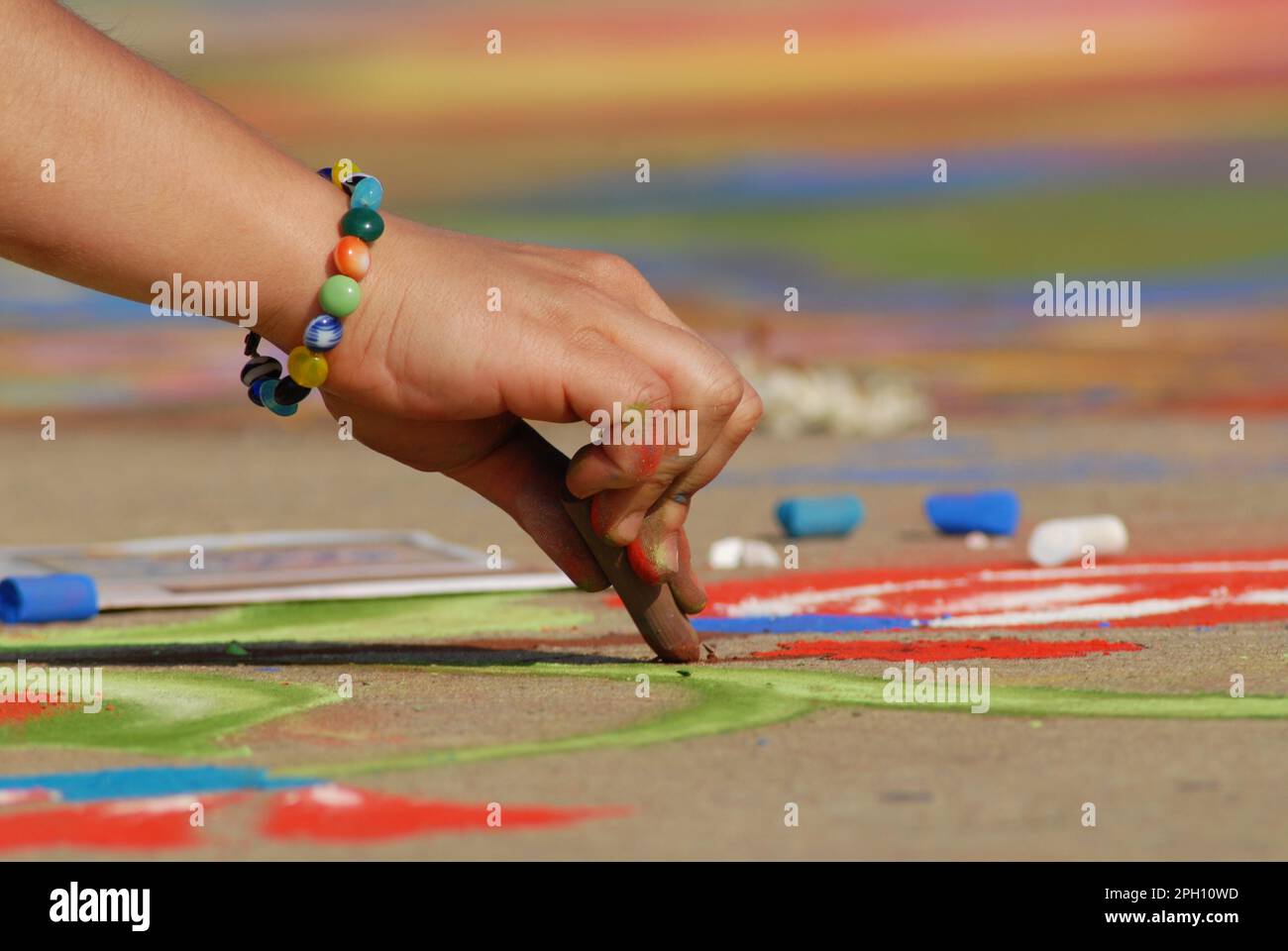 An artist hand at work making beautiful works of art on the street ...