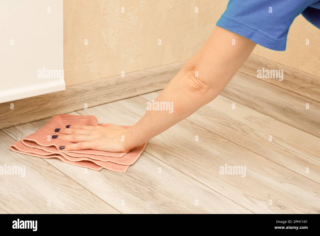 woman wipes the floor in the room with a damp cloth. wet floor cleaning ...