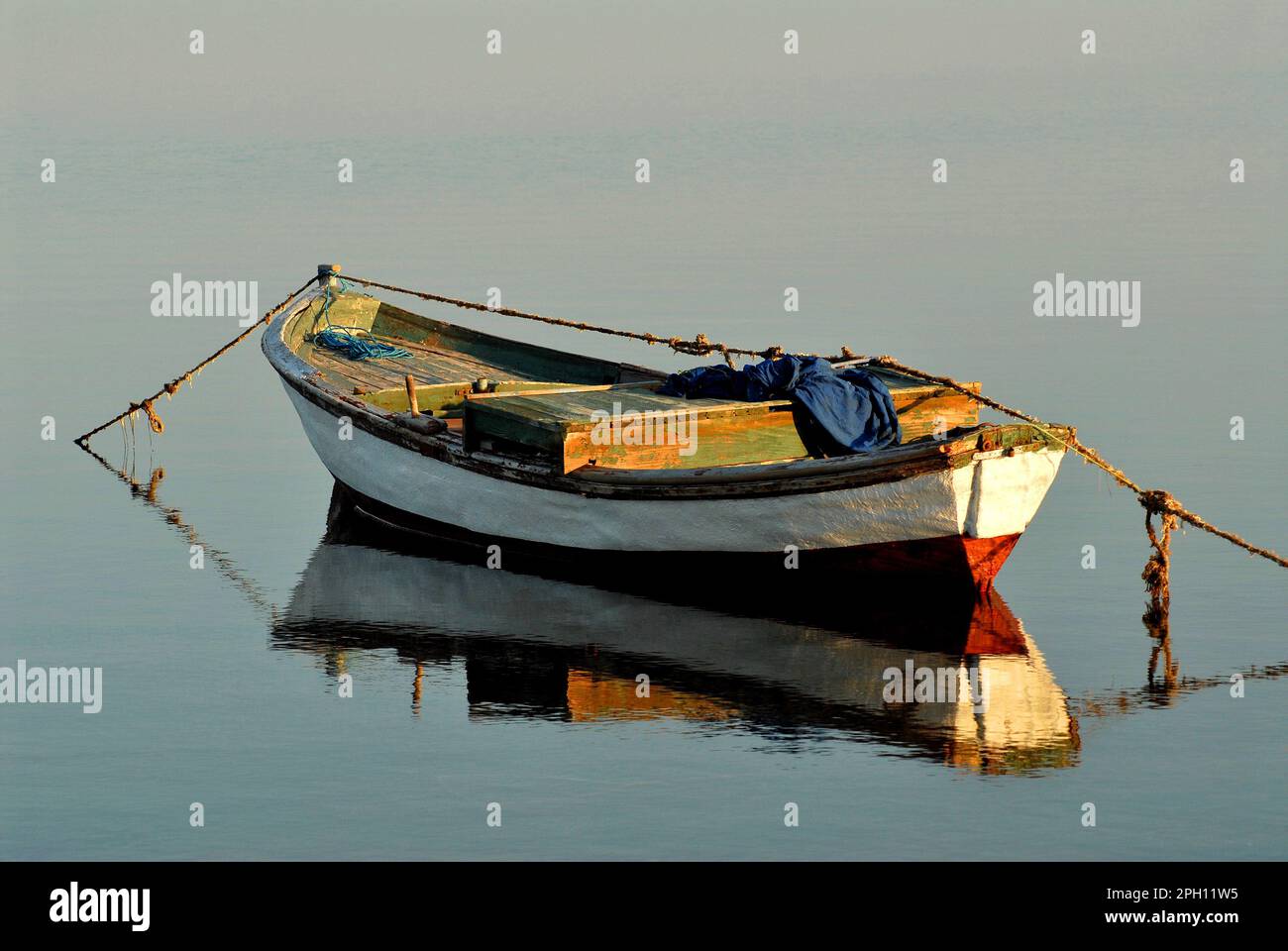 fishing boat and its reflection on the sea Stock Photo - Alamy