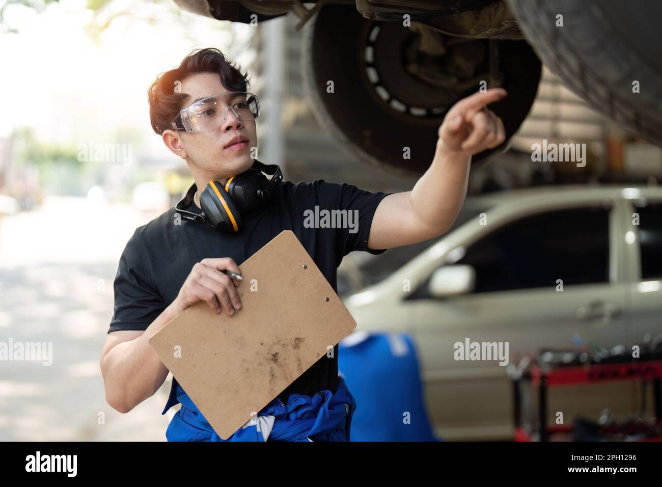 Vehicle service maintenance asian man checking under car condition in ...