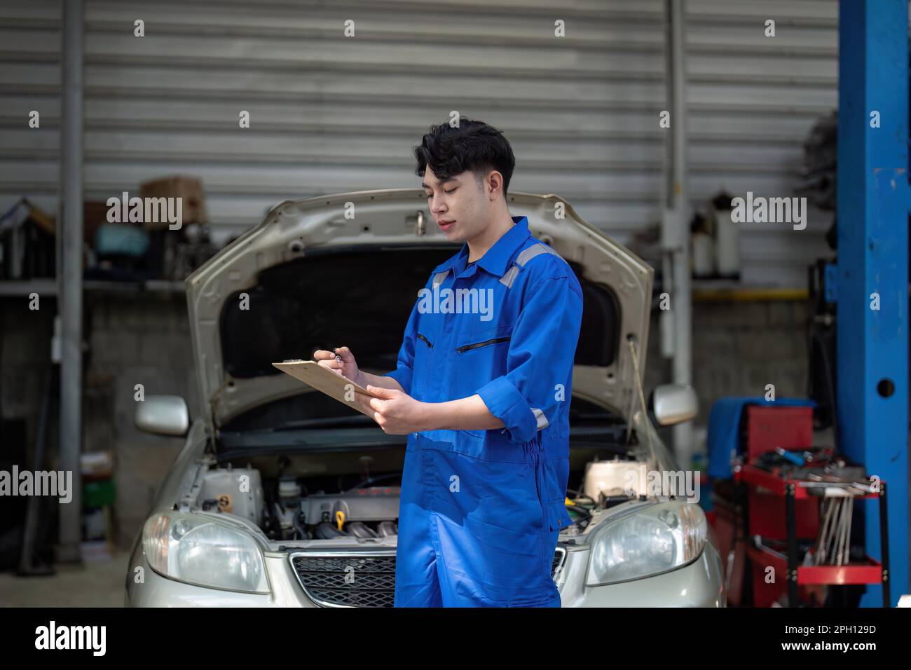 Vehicle service maintenance asian man checking under car condition in ...
