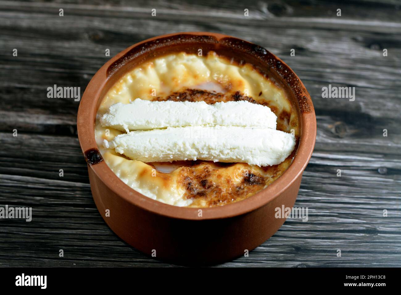 Rice pudding pottery casserole topped with milk cream, rice, corn flour ...