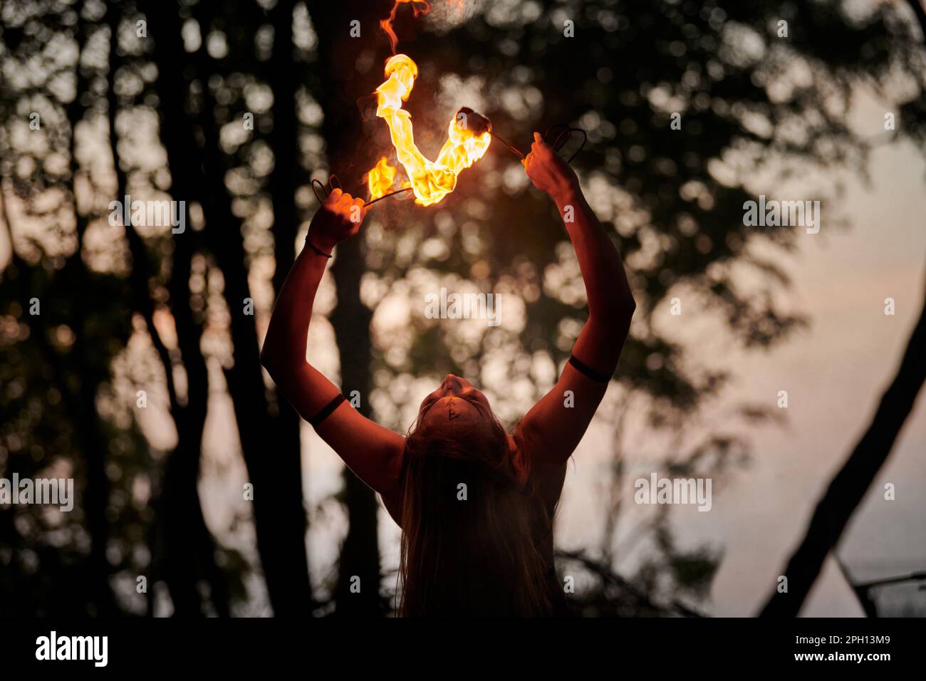 Girl fire dancing performance at outdoor art festival, smooth movements ...