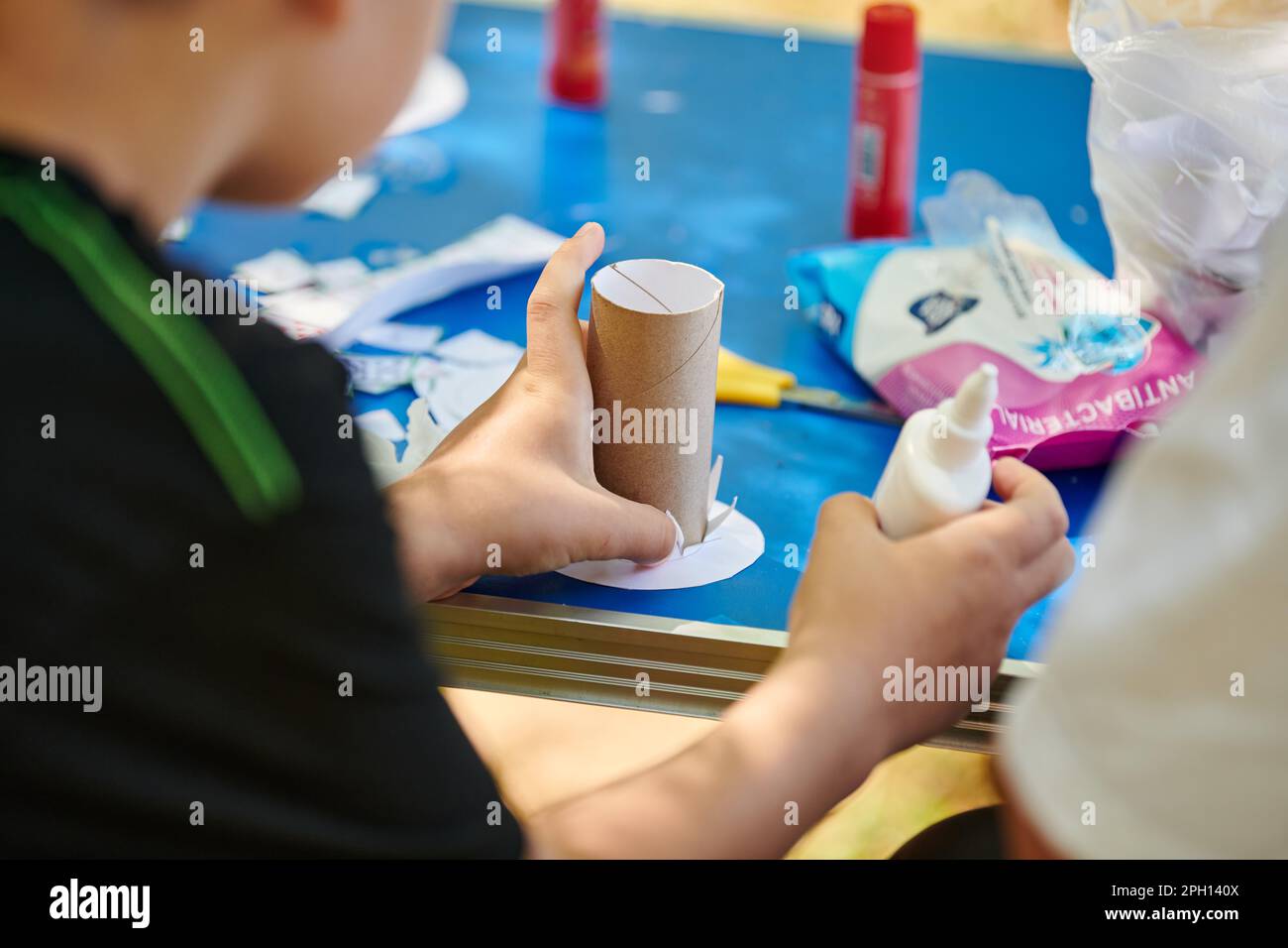 Children paper crafting with parents in outdoor children party ...