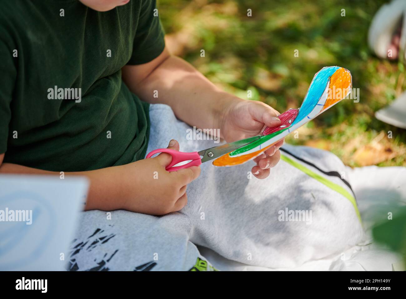 Children paper crafting with parents in outdoor children party ...