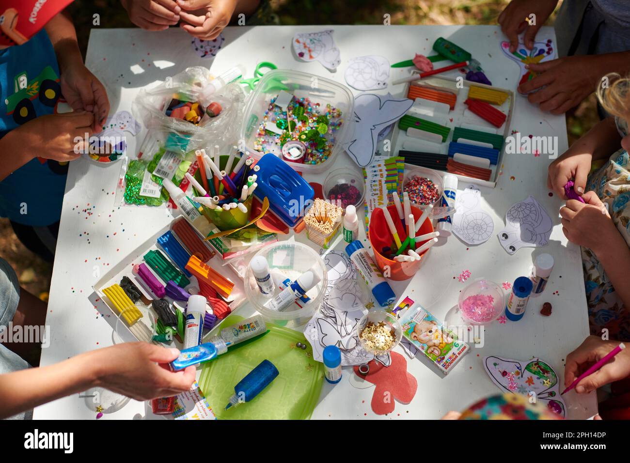 Children paper crafting with parents in outdoor children party ...