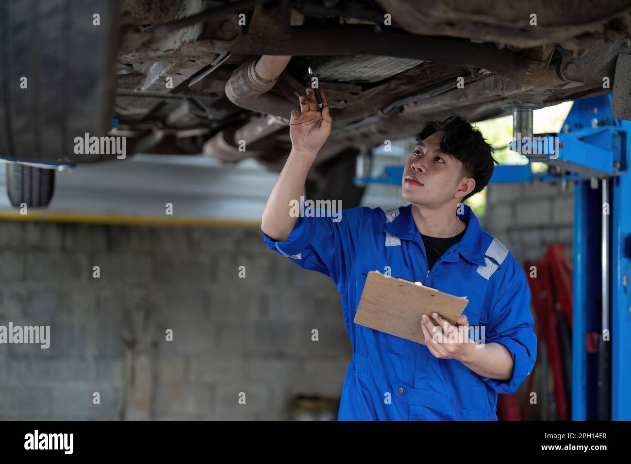 Vehicle service maintenance asian man checking under car condition in ...