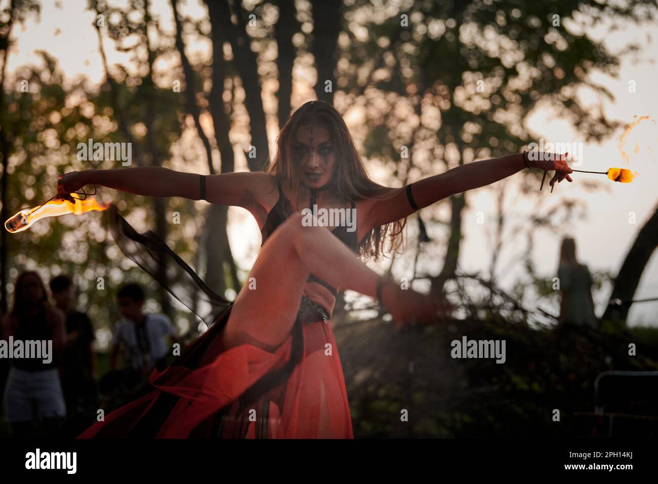 Girl fire dancing performance at outdoor art festival, smooth movements ...