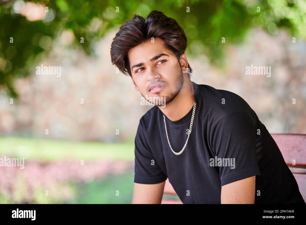 Attractive indian man smoker exhales cigarette smoke portrait in black ...