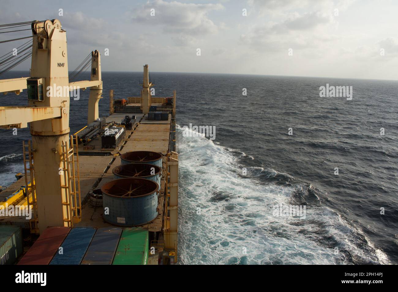 A general cargo merchant ship fitted with heavy lift cranes is underway ...