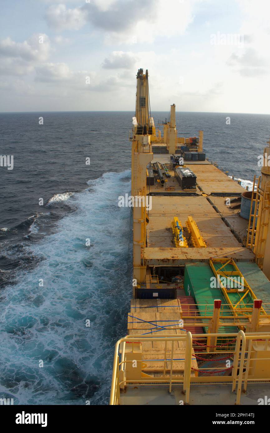 A general cargo merchant ship fitted with heavy lift cranes is underway ...