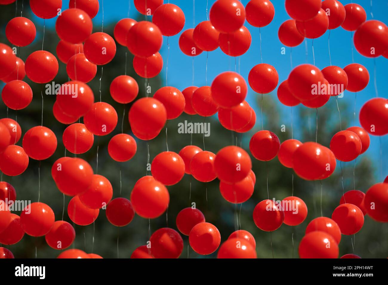 Red balls suspended on wire, outdoor art object symbolizing blood cells ...