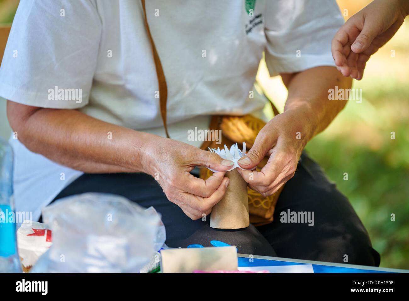 Children paper crafting with parents in outdoor children party ...