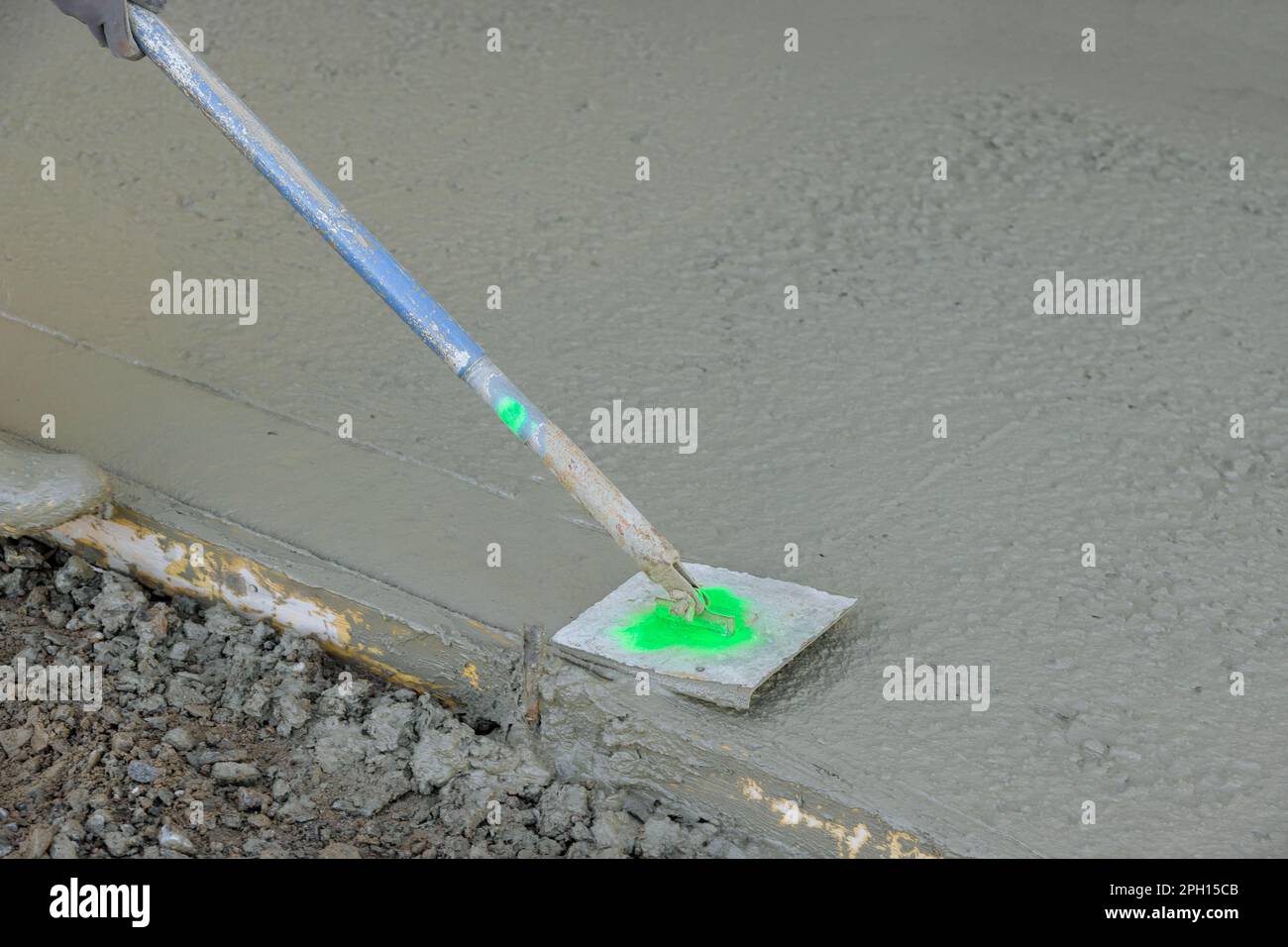 On freshly installed cement floor an employee of construction company ...