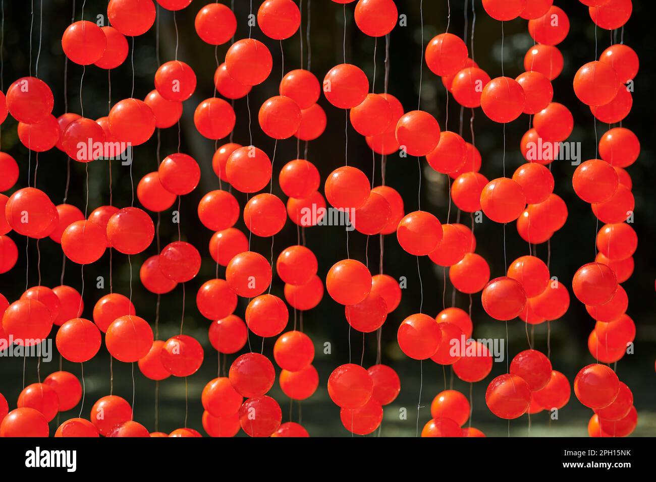 Red balls suspended on wire, outdoor art object symbolizing blood cells ...