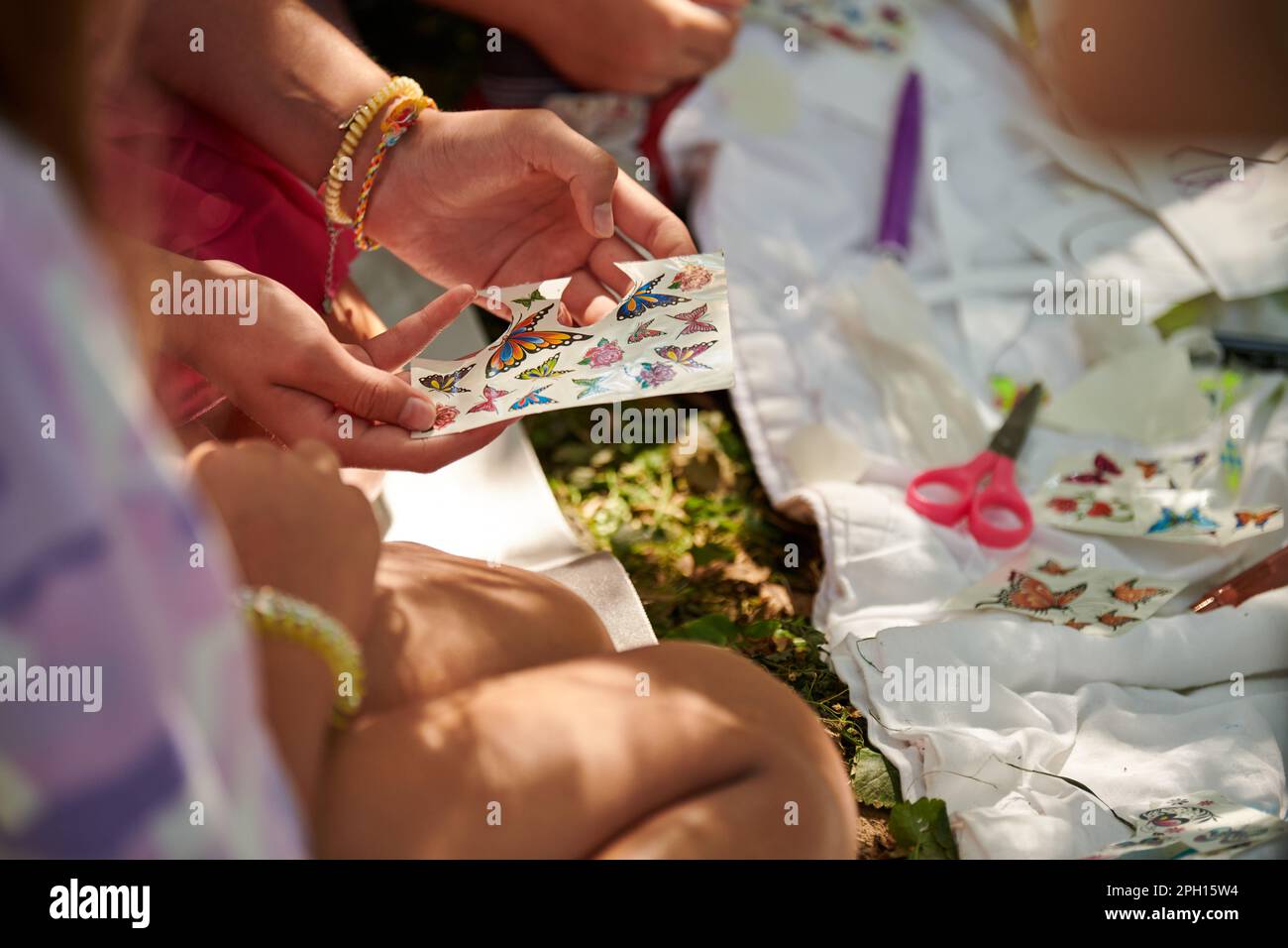 Children paper crafting with parents in outdoor children party ...