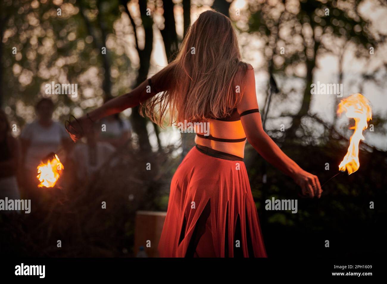 Girl fire dancing performance at outdoor art festival, smooth movements ...