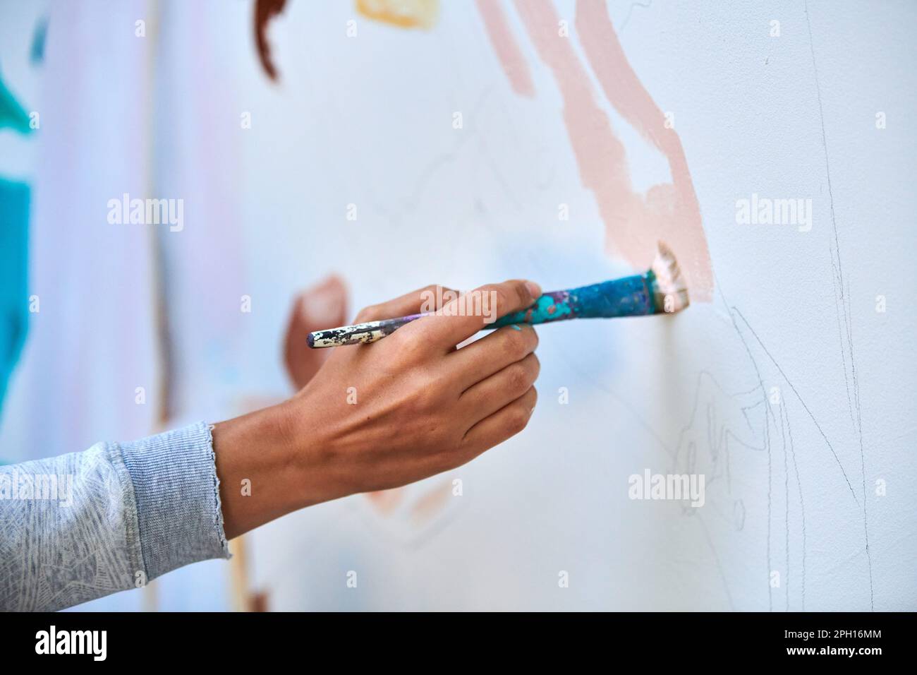 Artist hand holds paint brush and draws abstract surreal image on white ...